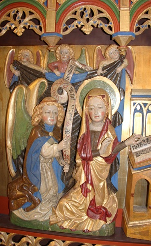 Der linke Flügel zeigt die Verkündigung an Maria.Vor einem Vorhang, den ...